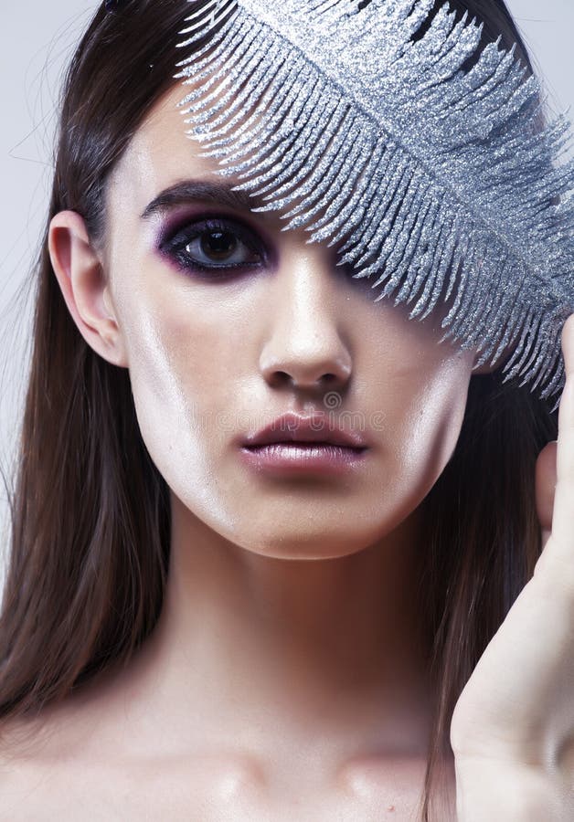 Beauty Brunette Young Girl With Fashion Makeup And Silver Feather