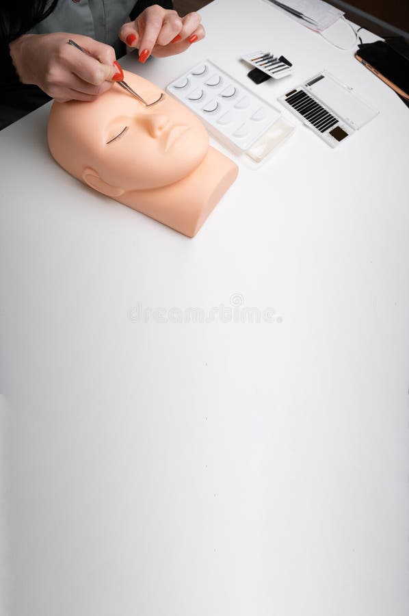 A Beauty Mannequin Training Head with a Woman Practicing Lash Extension ...