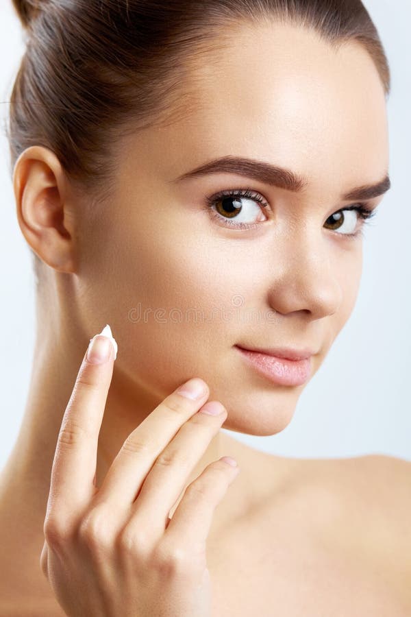 Beauty Happy Young Woman Applying Cream To Her Face Skincare And