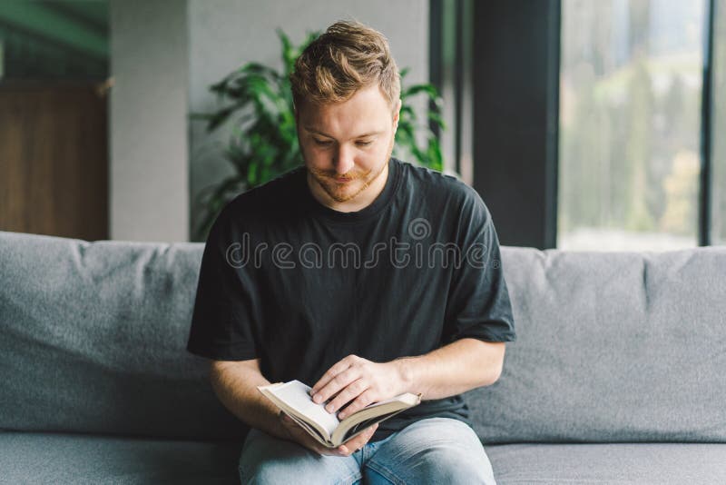 Beauty Young Man is Reading a Book at Home. Thoughtful Man Reading ... Beauty Young Man is Reading a Book at Home. Thoughtful Man Reading ...