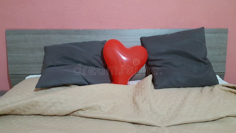 Bed with Two Pillows and a Heart Shaped Balloon Stock Photo - Image of ...