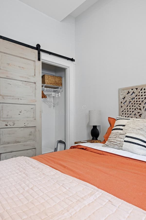 A Bed with a Wooden Head Board on it Next To an Open Closet Stock Photo ...