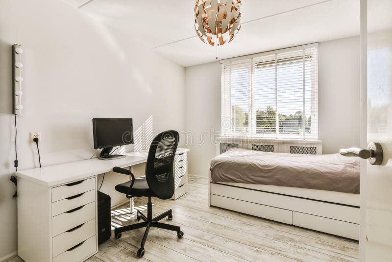 A Bedroom with a Bed a Desk and a Computer Stock Photo - Image of ...