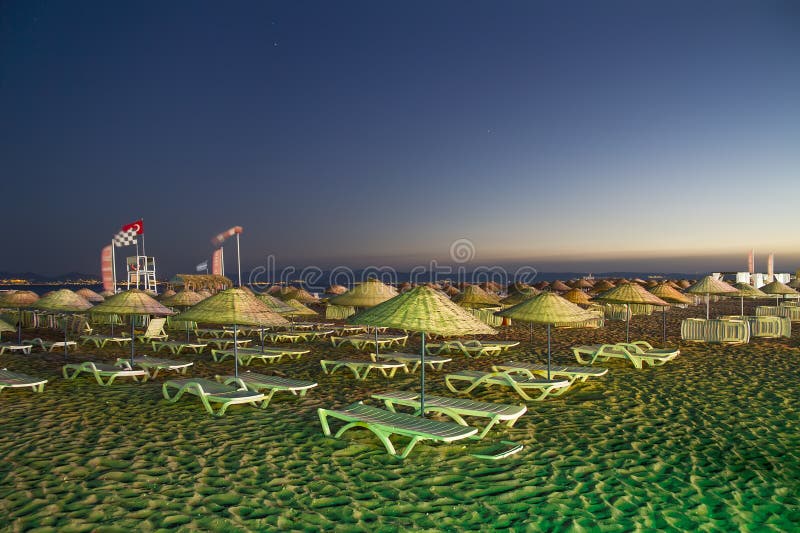 Beds and Straw Umbrellas on a Beach at Night Stock Photo - Image of ...