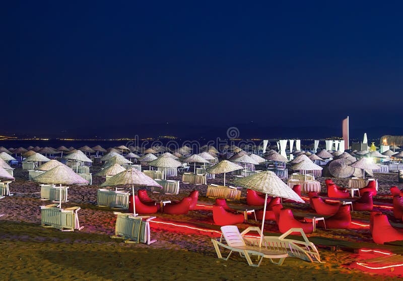 Beds and Straw Umbrellas on a Beach at Night Stock Image - Image of ...