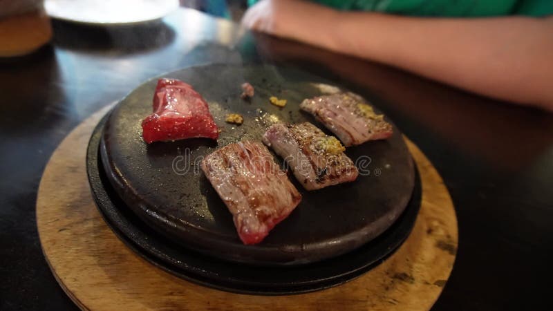 Beef cooking on a hot rock stock footage. Video of dish - 304836458