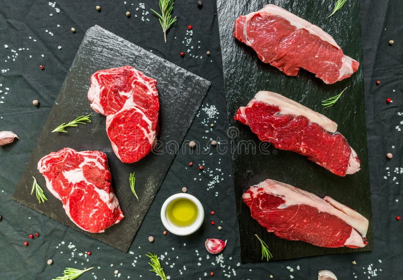 Beef Cow Meat Steaks with Spices and Herbs Against Black Background ...