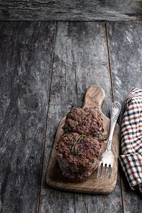 Beef Cutlets on Wooden Board on Rustic Wooden Table Stock Image - Image ...