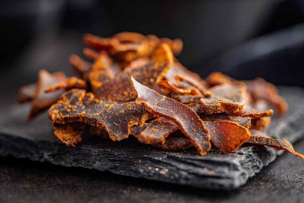 Beef Jerky. Dried Spiced Meat on Black Table Stock Photo - Image of ...