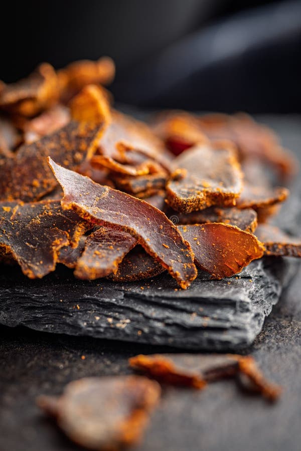 Beef Jerky. Dried Spiced Meat on Black Table Stock Photo - Image of ...