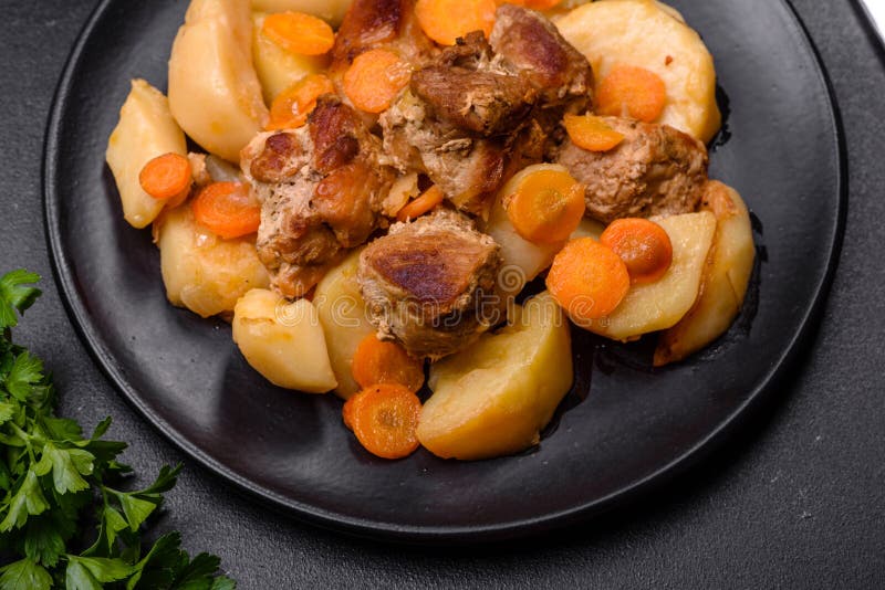 Beef Meat and Vegetables Stew on a Black Plate with Roasted Potatoes ...