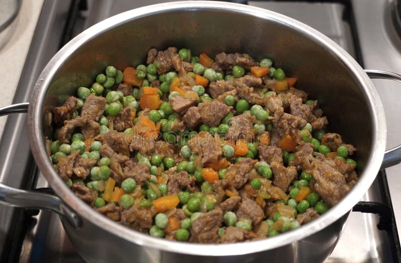 Beef, Peas, Carrots and Spices are Cooked Slowly in a Pot on the Stove ...