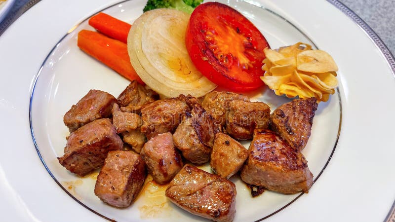 Beef Steak Cut into Squares in a Plate with Tomatoes, Onions, Carrots ...