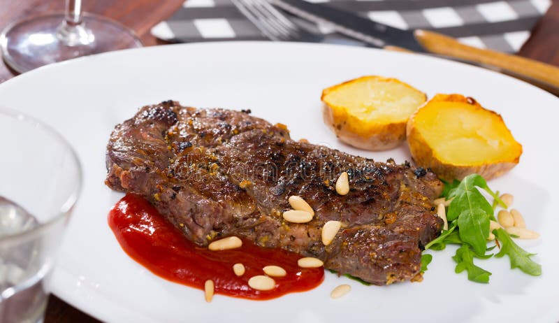 Beef Steak with Ketchup and Pine Nuts, Served with Potatoe Stock Photo ...