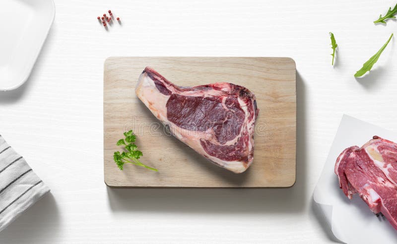 Beef Steak Over a Cutting Board with Various Food Items Stock Photo ...