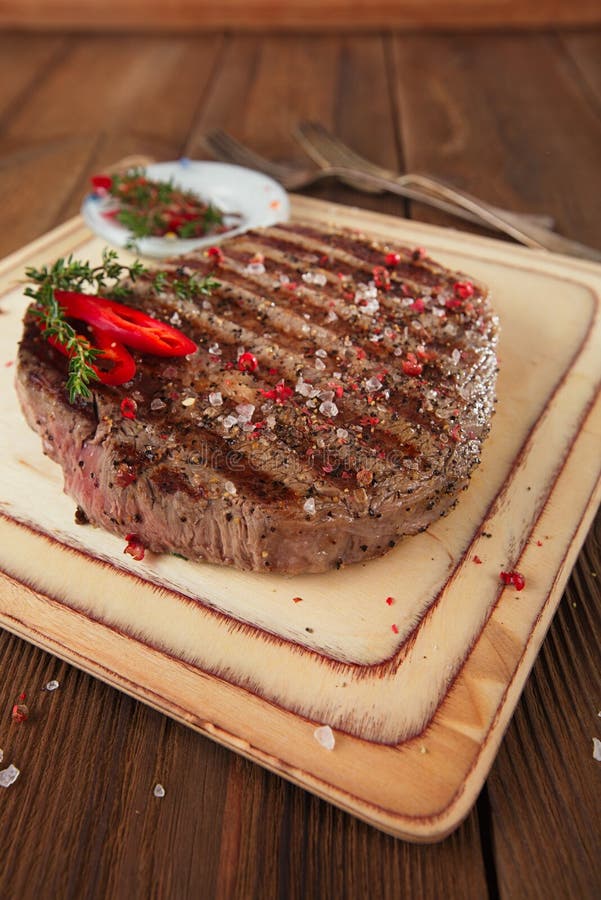 Beef Steak on a Wooden Board and Table Stock Image - Image of spices ...