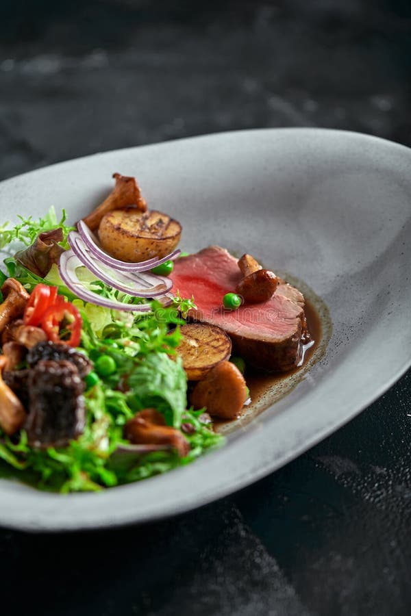 Beef Tagliata with Vegetables. Close-up, Low Key, Gray Background ...