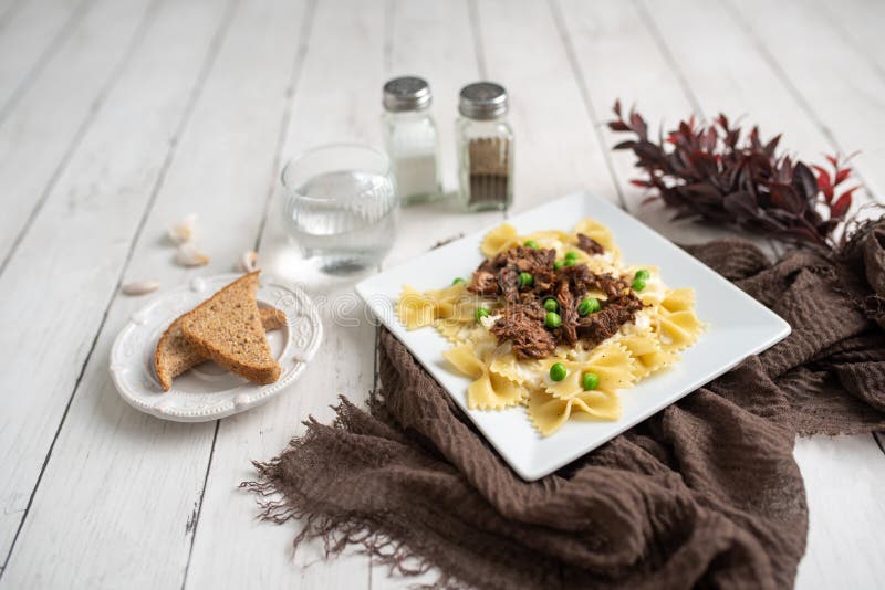 Beef Tips Over Bow Tie Pasta and Alfredo Sauce Stock Photo - Image of ...
