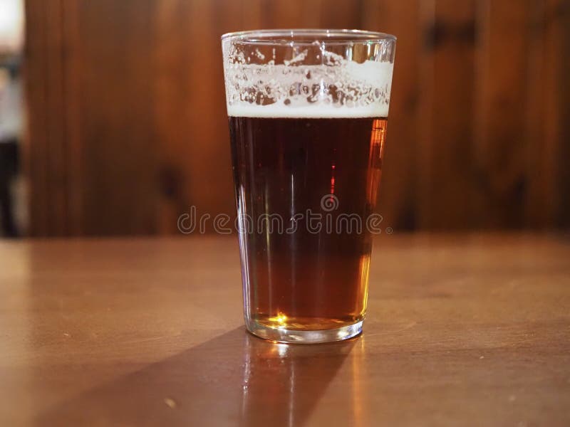 Beer pint in pub stock photo. Image of alcoholic, glass - 355773886