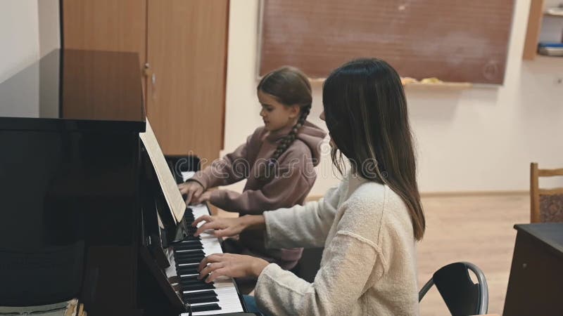 A Beginner Pianist Practices Under a Teachers Supervision, Mastering ...