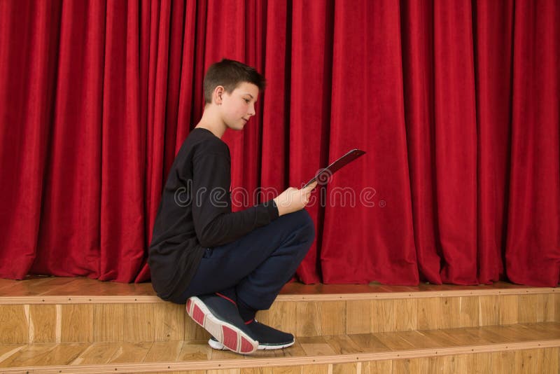 Backstage at the Stage, a Young Actor is Carefully Studying His Script ...