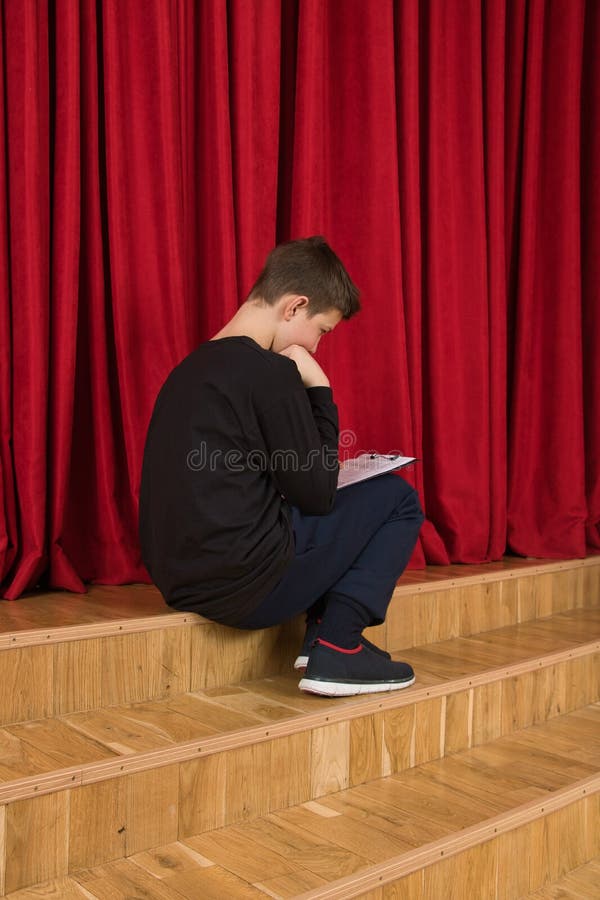 Backstage at the Stage, a Young Actor is Carefully Studying His Script ...