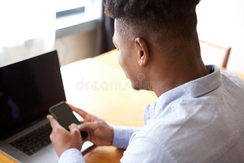 Behind of Young Man Holding Mobile Phone in Front of Laptop Computer ...
