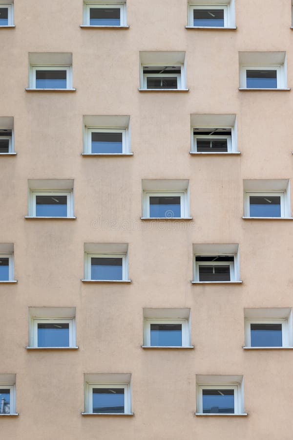 A Beige Building Facade with Small, Uniformly Arranged Square Windows ...