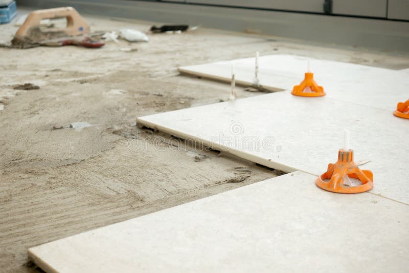 Beige Stone Tile Floor Being Installed with Orange Spacers Stock Image - Image of interior ...