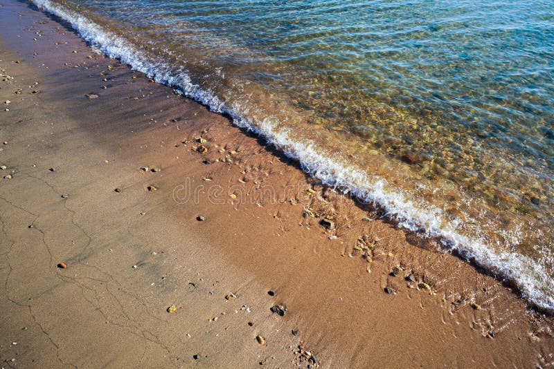 A Small Wave with Foam Rolls on the Sea Pebbles Stock Image - Image of ...