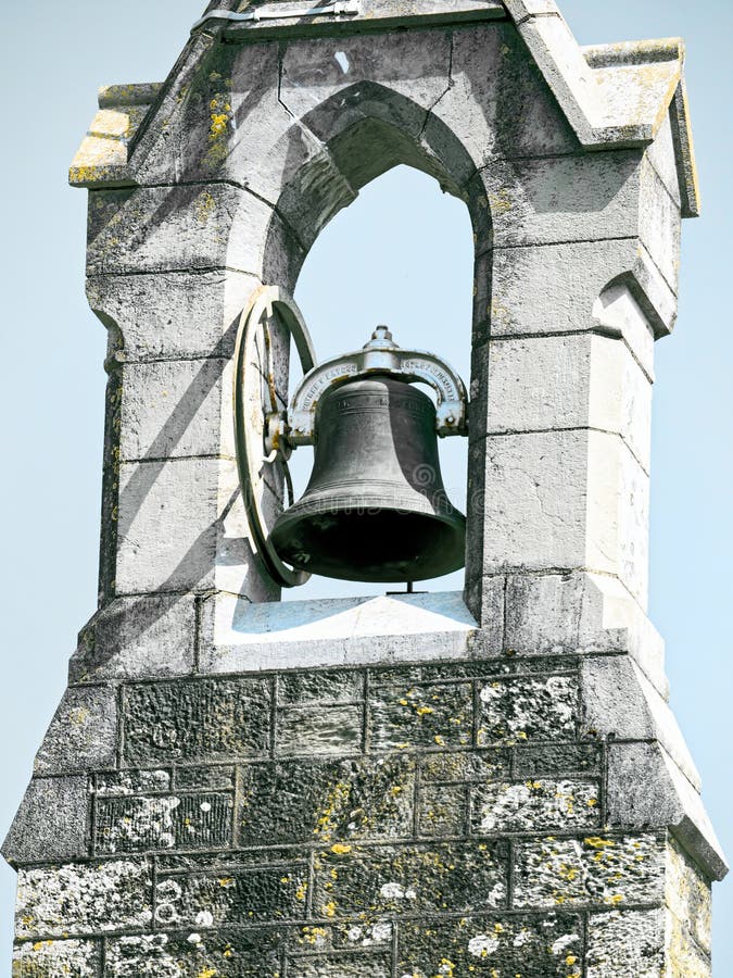 A Bell is Mounted on a Stone Tower. the Bell is Made of Metal and Has a ...