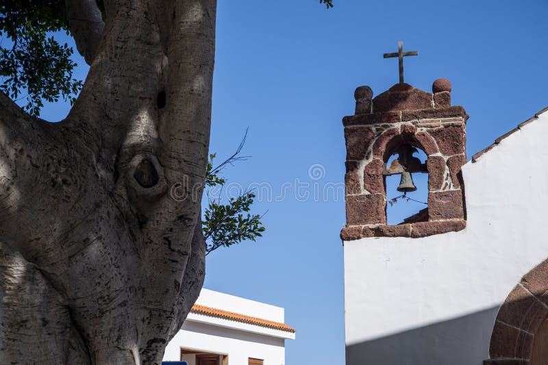 A Bell Tower with a Red and White Design Stands in Front of a White ...
