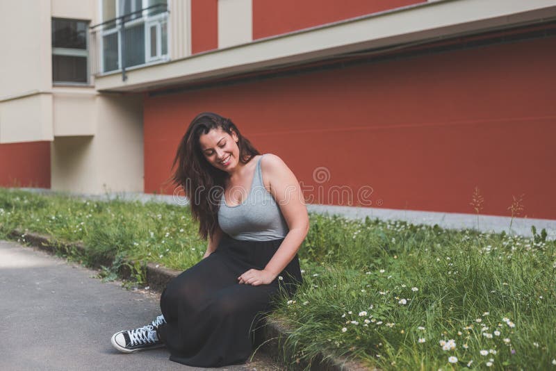 Bella Ragazza Formosa Seduta Nell'erba Fotografia Stock - Immagine di ...