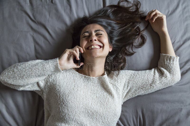 Bella Ragazza Felice Che Si Trova Sul Letto E Che La Parla Sul Telefono ... Bella Ragazza Felice Che Si Trova Sul Letto E Che La Parla Sul Telefono ...