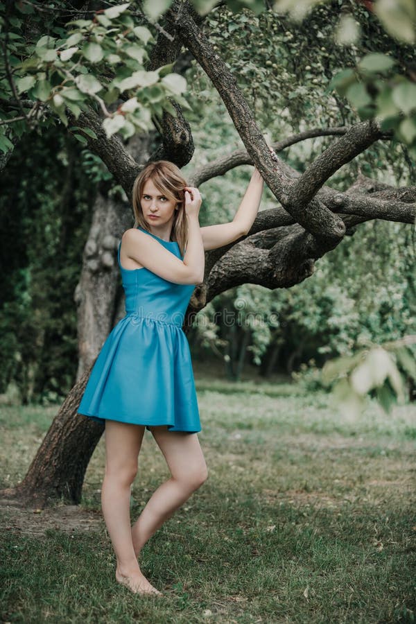 Belle Fille Aux Pieds Nus Dans La Robe Bleue Se Tenant Dans Larbre