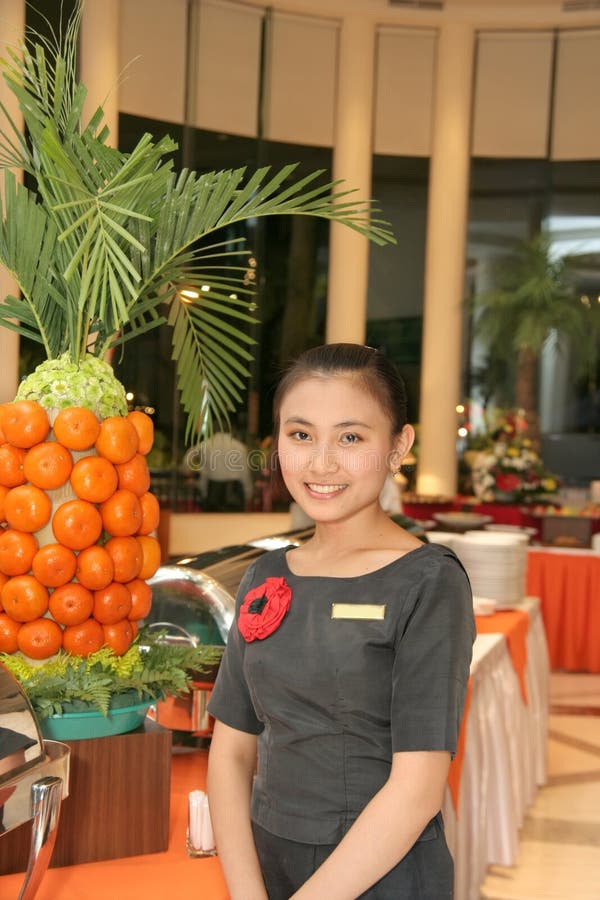 Belle serveuse au buffet image stock. Image du orange - 6031989