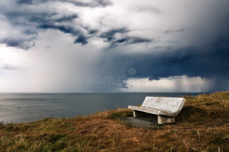 Bench on Cliff with Storm Over Sea Stock Photo - Image of raining ...