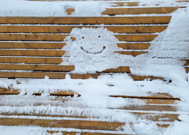 A Bench Covered with White Snow with a Painted Face with a Smile. Stock ...
