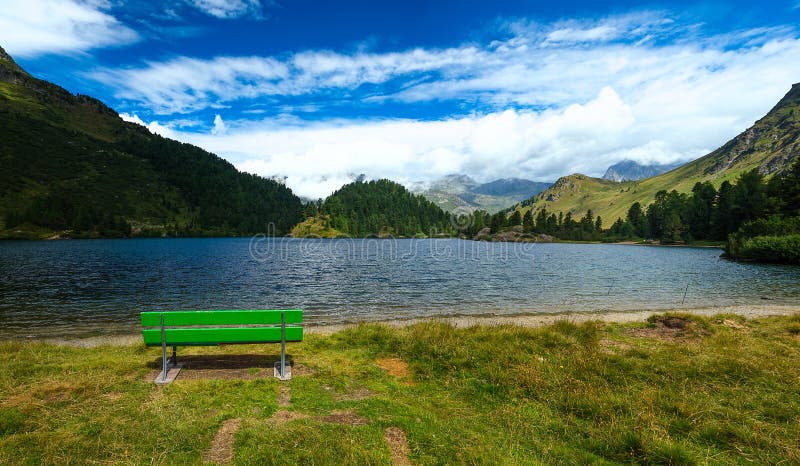 Bench in Front of an Alpine Lake Stock Photo - Image of lake, woods ...