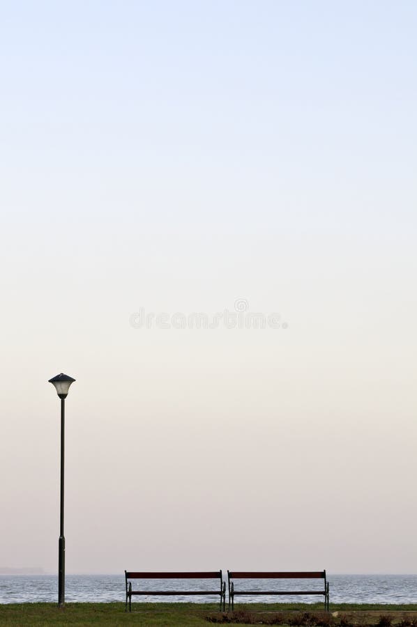 Bench and Lamp Post at Lakeside Vertical Stock Photo - Image of distant ...