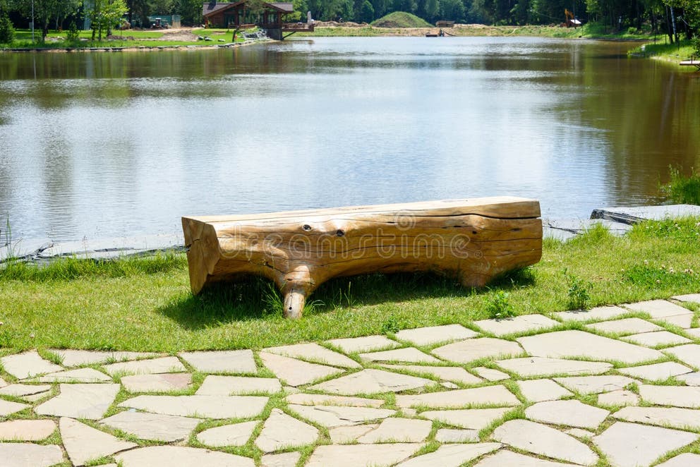 A Bench Made of a Solid Tree Trunk on the Bank of a Pond. Stock Image ...