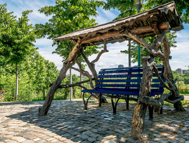 Bench in a Public Park with a Roof Made of Tree Trunks Stock Image ...