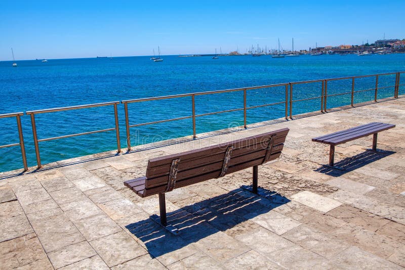 Bench on the ocean shore stock photo. Image of sailing - 156039630