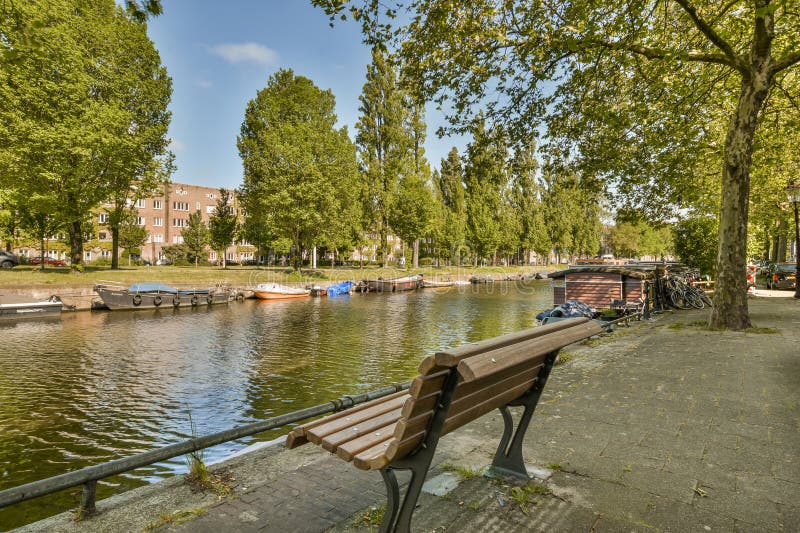 A Park Bench Overlooking a River with Boats on it Stock Image - Image ...