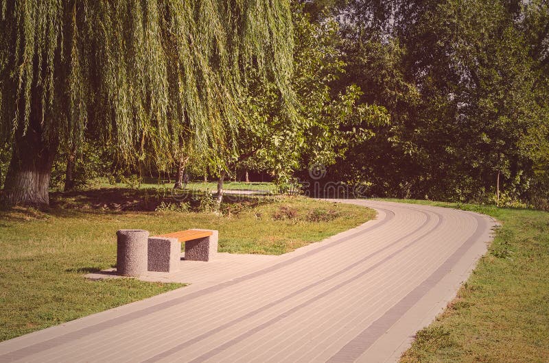 A Bench and a Winding Road. Toned Stock Image - Image of nature, garden ...