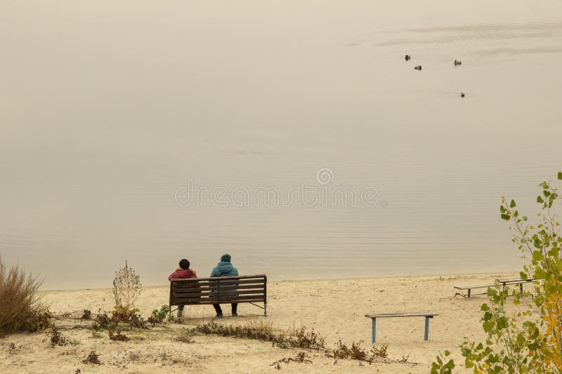Benches on the River Bank. Two People are Sitting on a Bench Stock ...