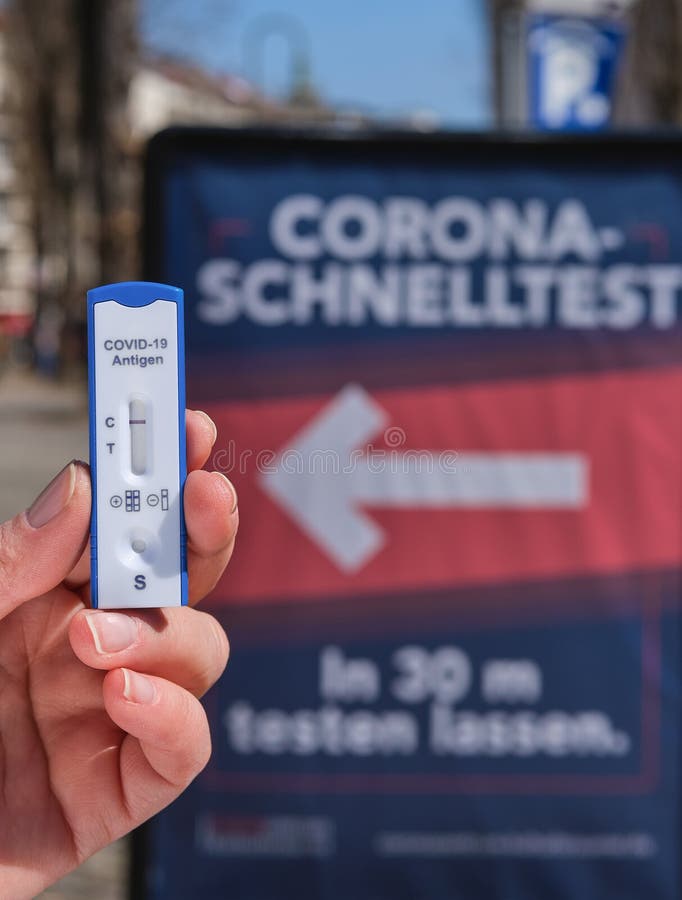 Hand Holding Express COVID-19 Test in Front of Advertising for Quick ...