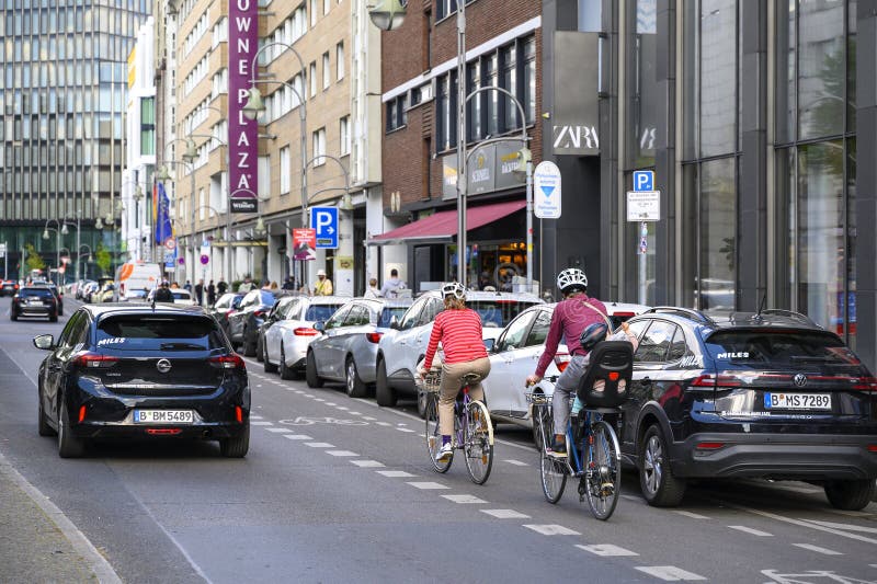 Street Scene with Two Cyclists on a Painted Cycle Path in the Center of ...