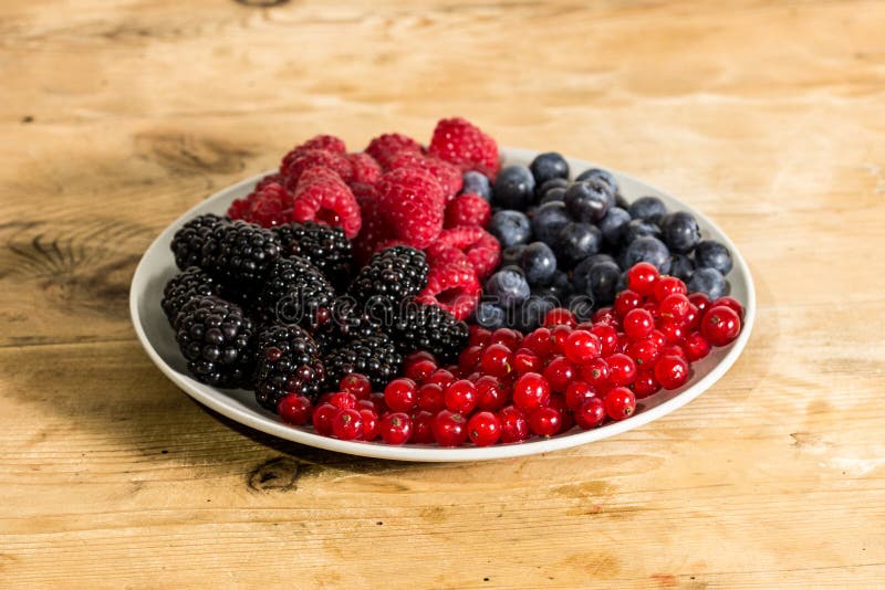 Berries in a Plate on a Wooden Table Stock Image - Image of currant ...