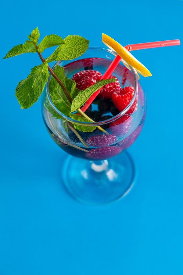 Berry Cocktail in a Glass with a Straw Lime and Mint and Mint on the ...